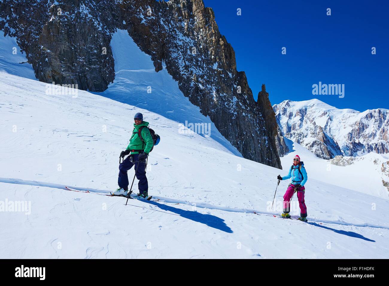 Mature male and female skiers moving up Mont Blanc massif, Graian Alps ...