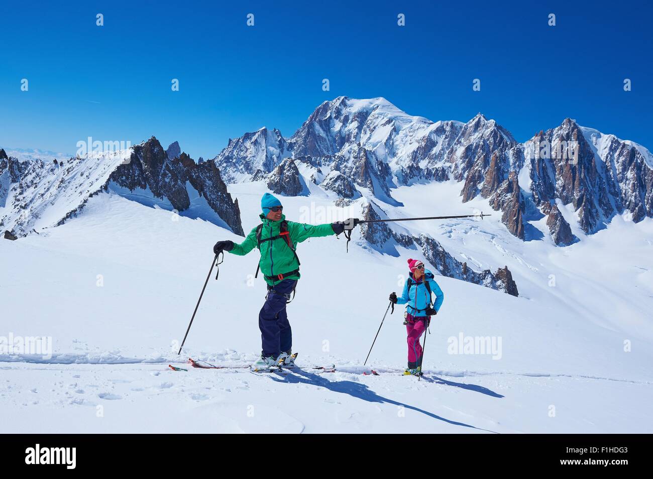 Male and female skiers pointing from Mont Blanc massif, Graian Alps ...
