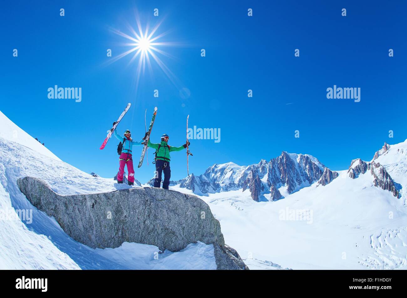 Male and female skiers holding up ski's on Mont Blanc massif, Graian ...