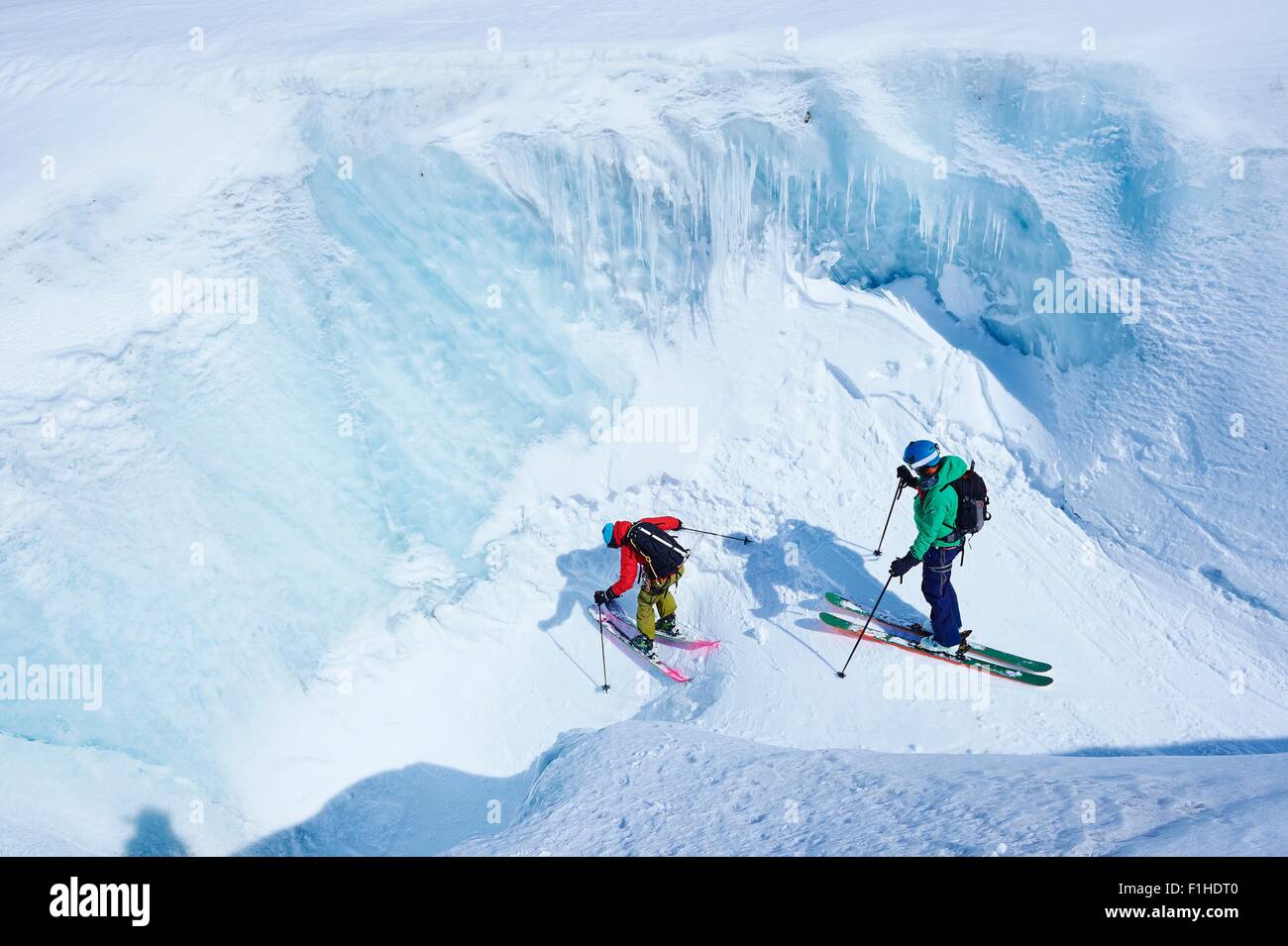 Two male skiers skiing down ravine on Mont Blanc massif, Graian Alps ...