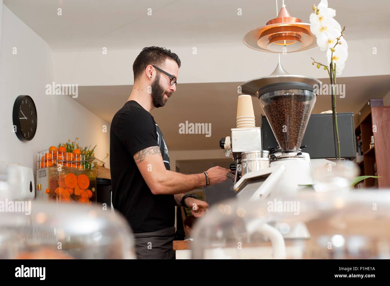 Cafe waiter preparing fresh coffee behind counter Stock Photo - Alamy