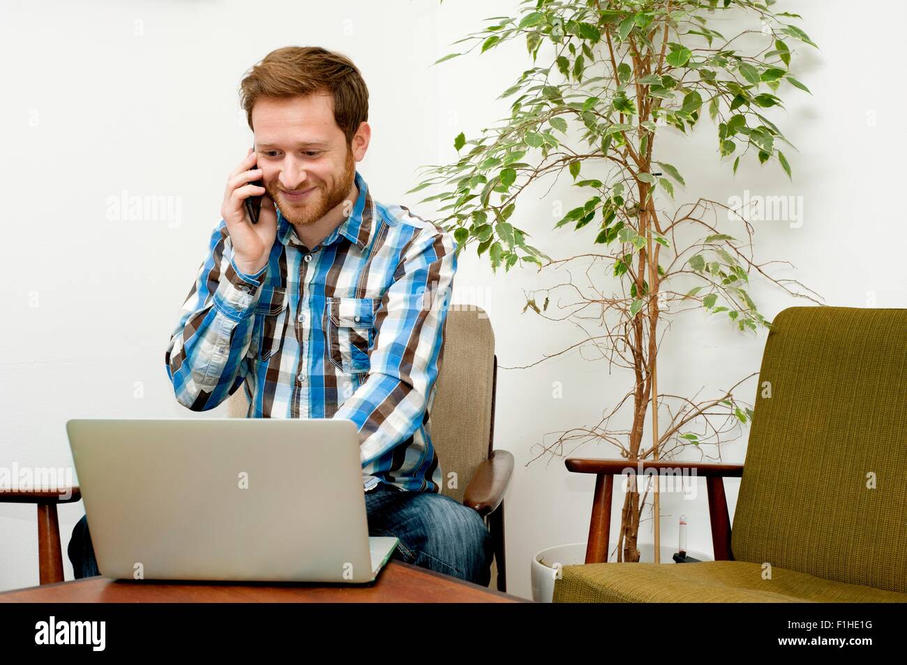 Male customer using laptop and smartphone in cafe Stock Photo - Alamy