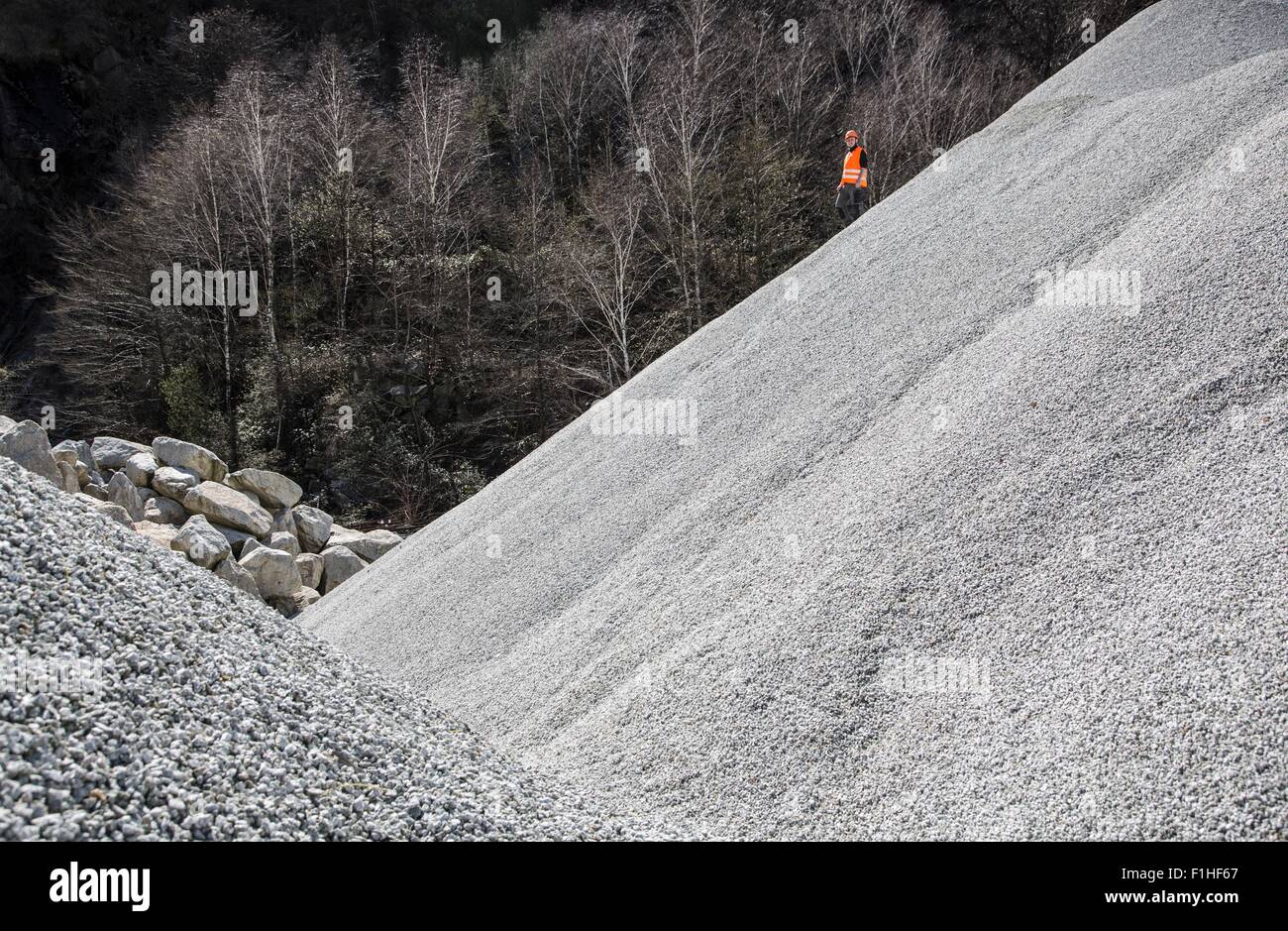 Quarry worker on gravel mound at quarry Stock Photo - Alamy