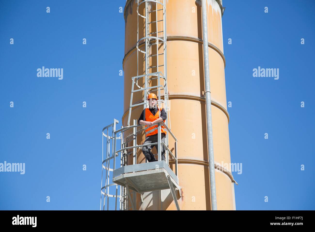 Portrait of worker on smoke stack viewing platform Stock Photo - Alamy
