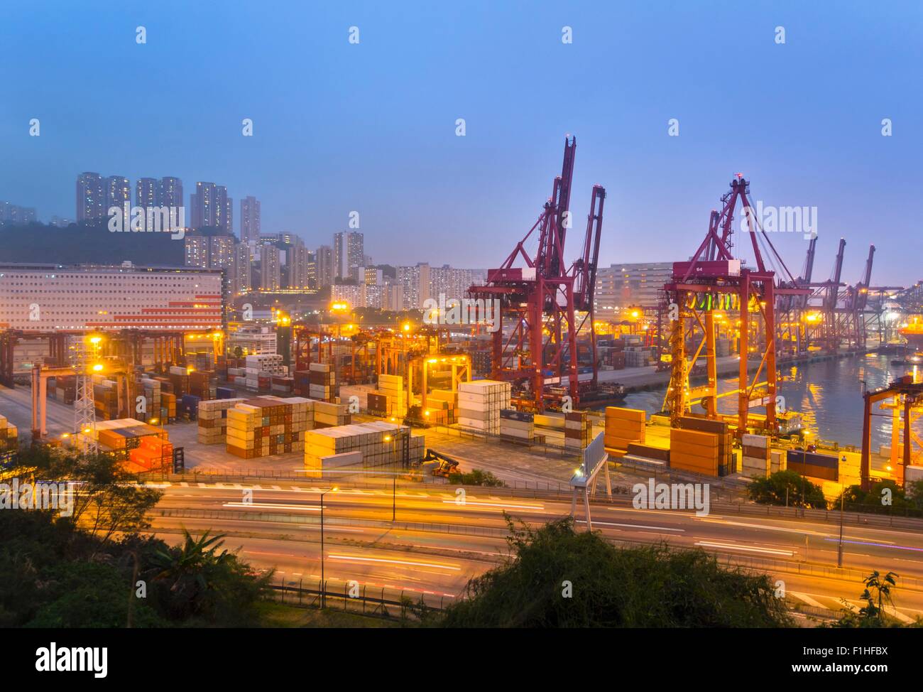 Cargo containers and loading cranes illuminated at night, Hong Kong ...