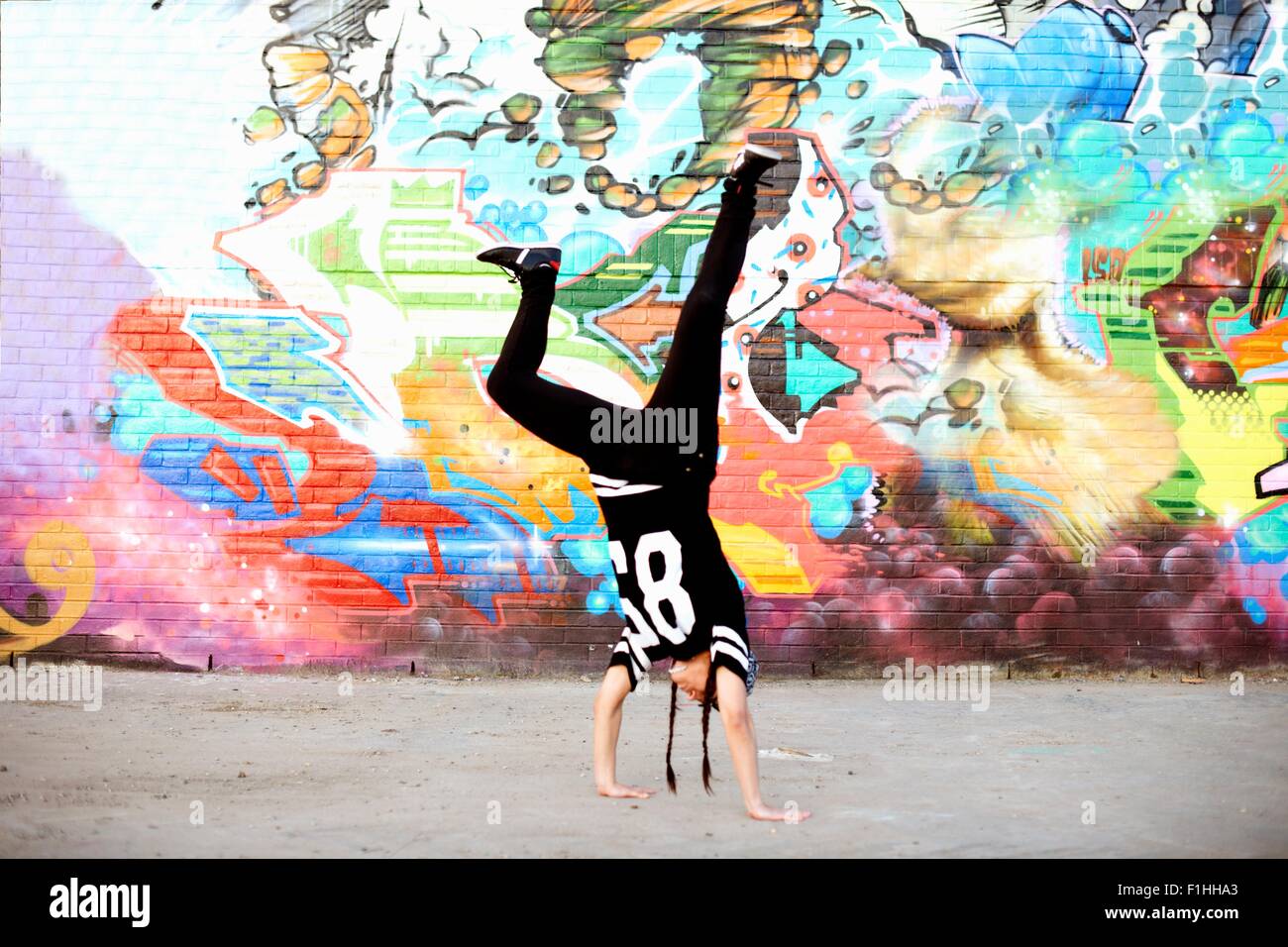 Young women in handstand breakdancing freeze against graffiti Stock ...
