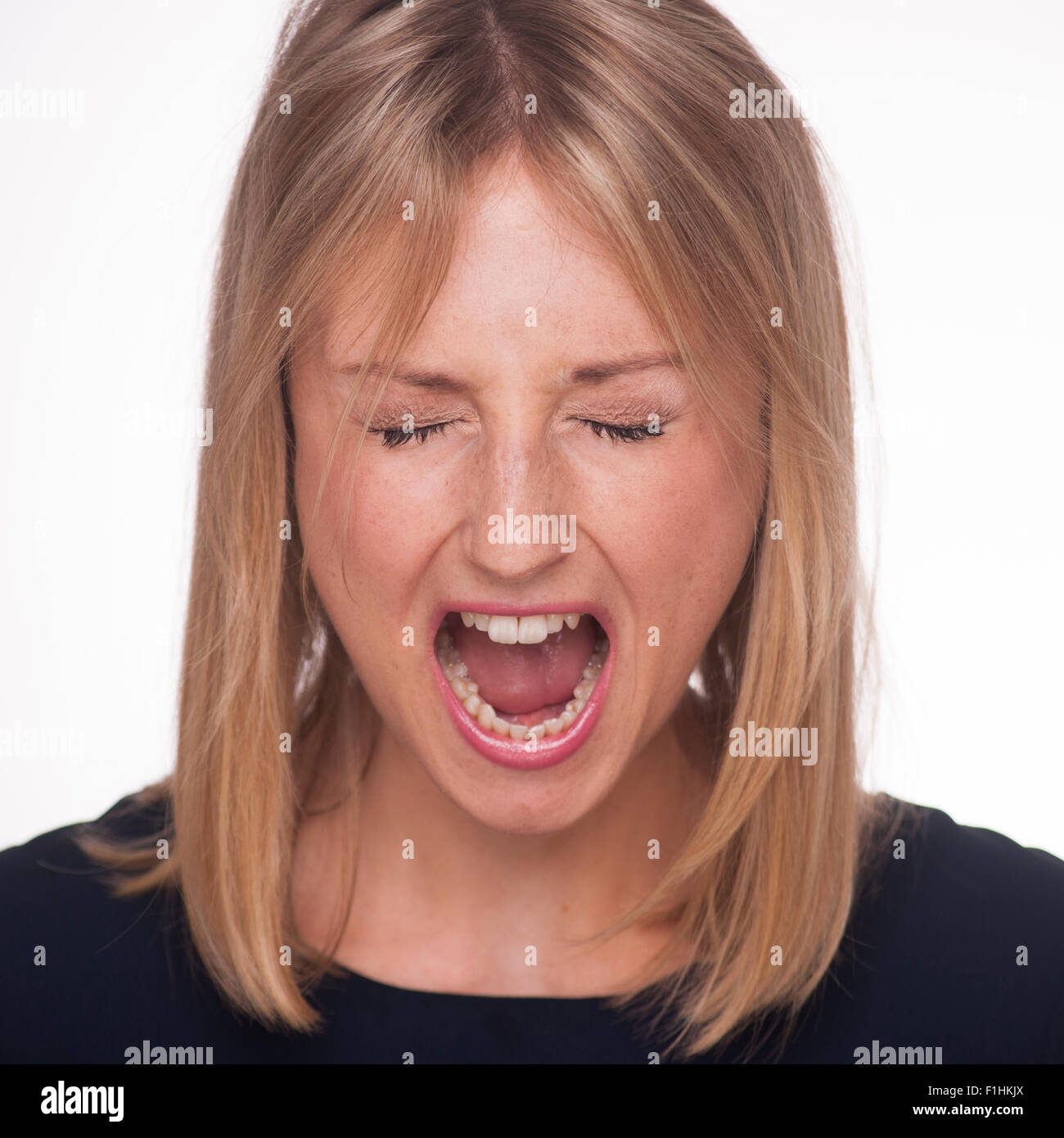 Blonde woman yelling with her eyes closed Stock Photo - Alamy