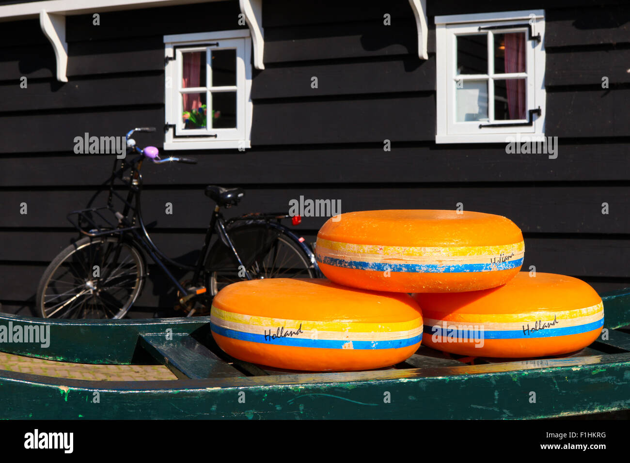 Dutch Cheese wheels on a green cart with farm house in the background ...