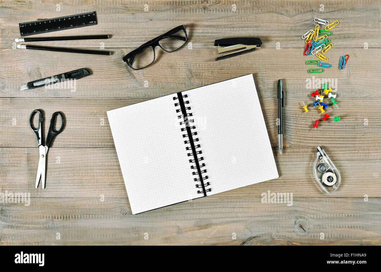 Office and school supplies over wooden desk background. Open book and ...