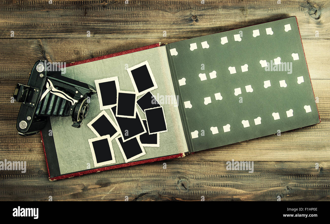 Vintage camera and album with old photo frames on wooden table. Retro ...