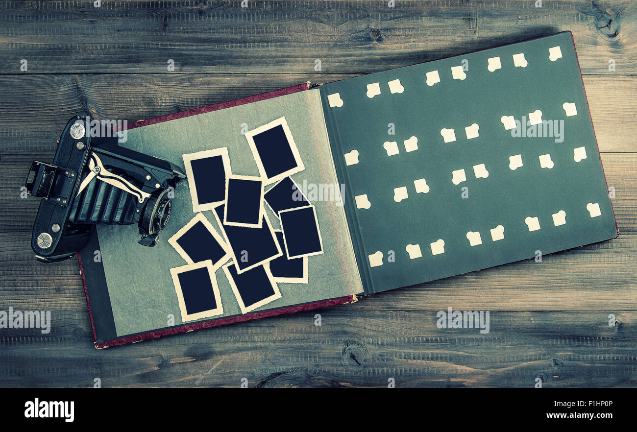 Vintage camera and album with old photo frames on wooden texture. Retro ...