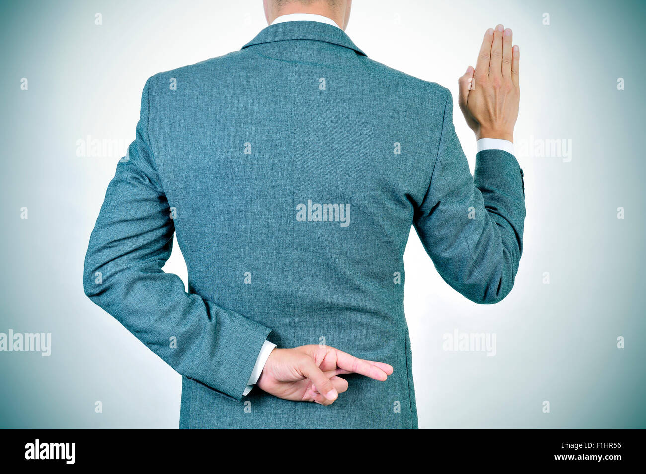 a young man in suit swearing an oath, rising his right hand, crosses ...