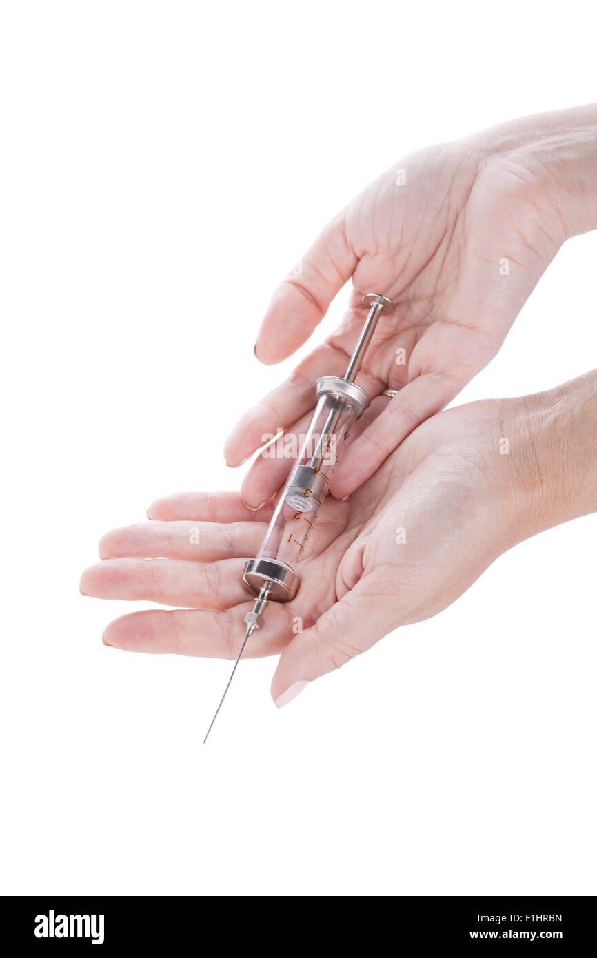 Old glass multiple use syringe in female hand, closeup on white ...
