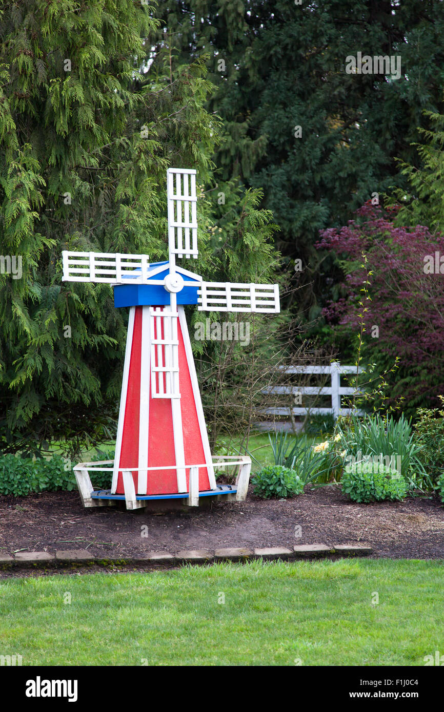 A red white and blue painted miniature wooden windmill is used as a ...