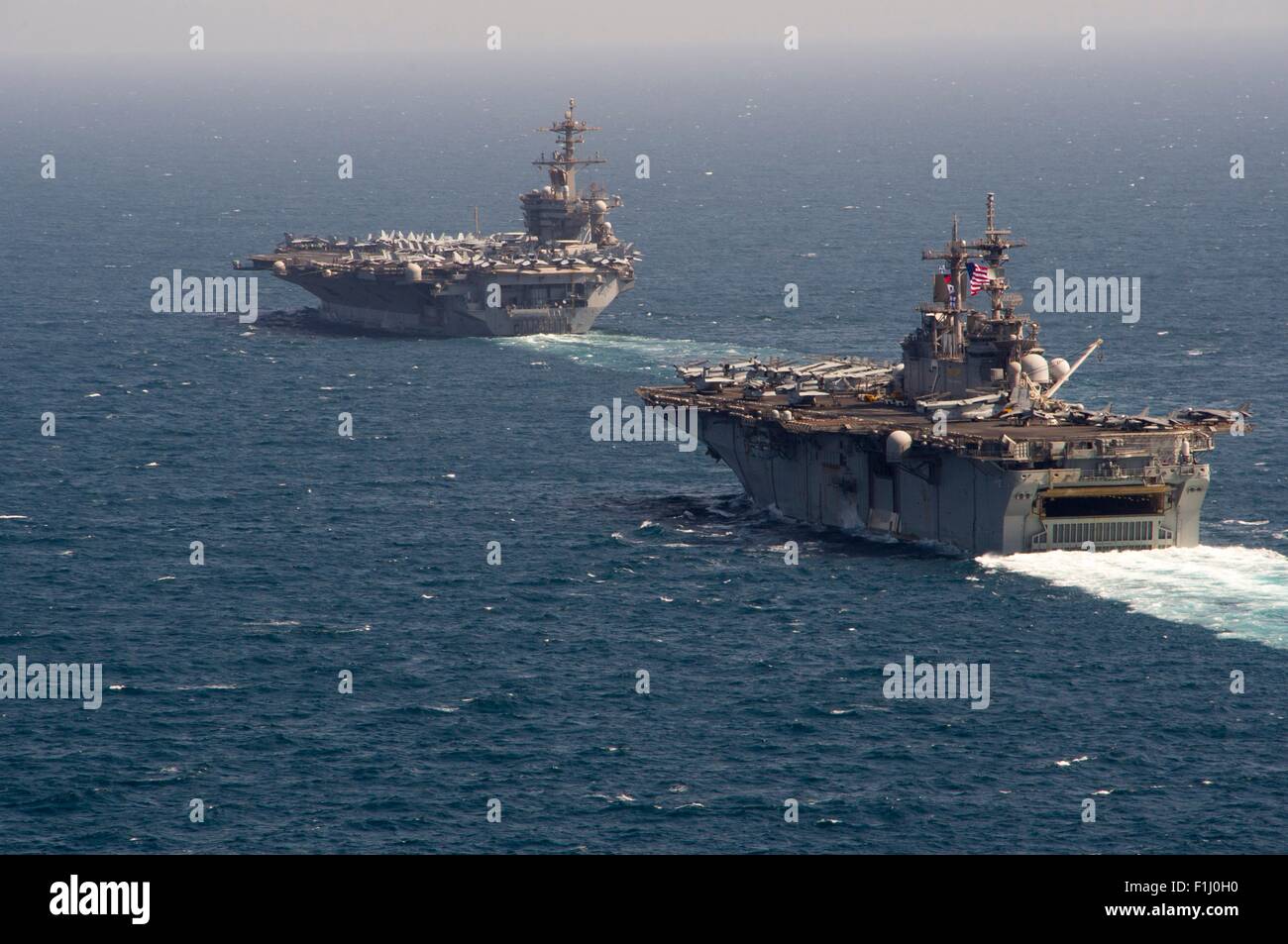 U.S. Navy Nimitz-class nuclear aircraft carrier USS Theodore Roosevelt transits alongside the ...
