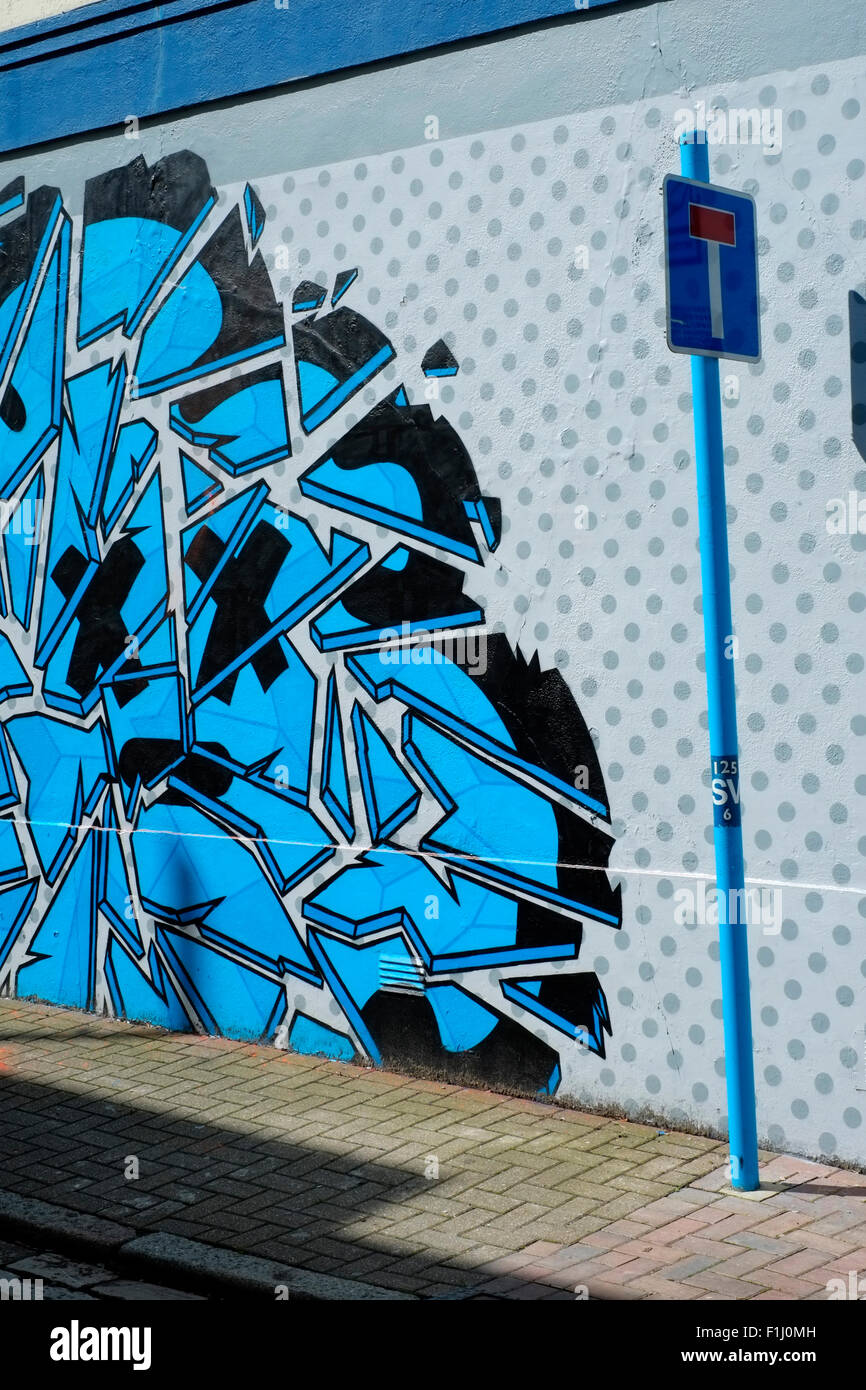 dead end road sign with matching blue graffiti on wall behind england ...