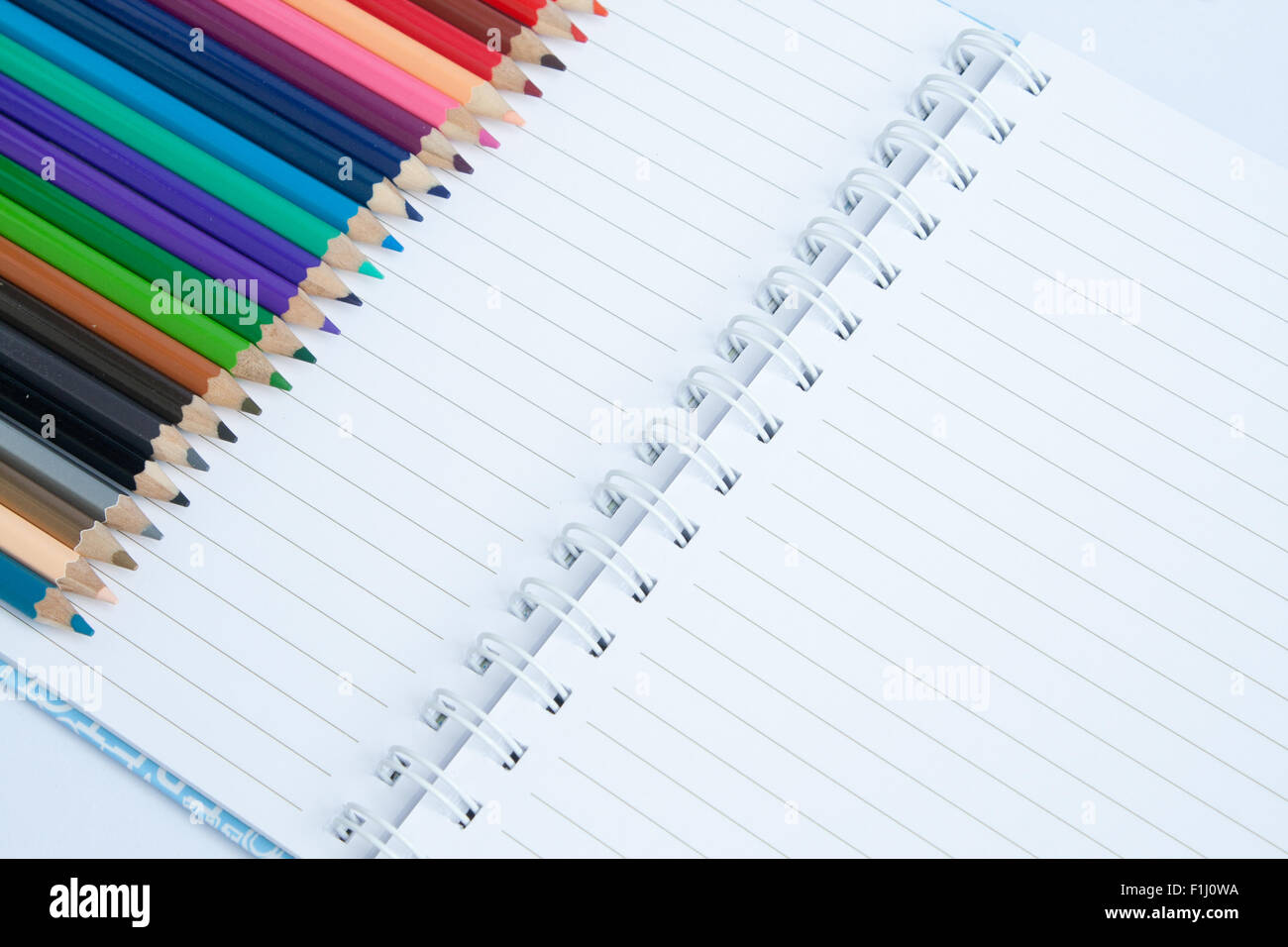 Note book and colored pencils Stock Photo - Alamy