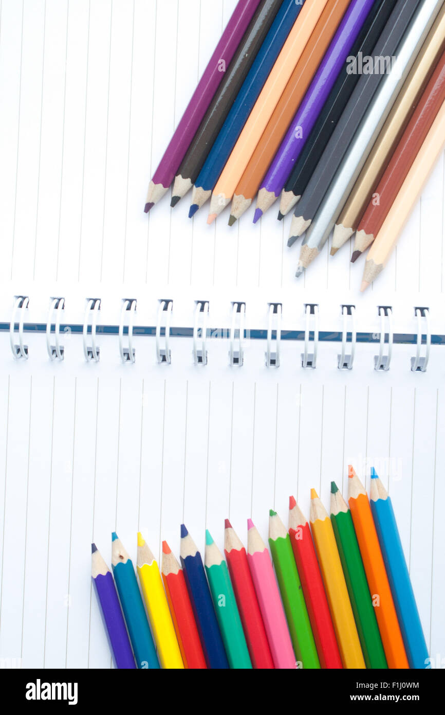 Note book and colored pencils Stock Photo - Alamy