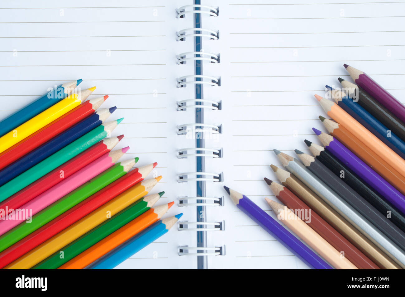 Note book and colored pencils Stock Photo - Alamy