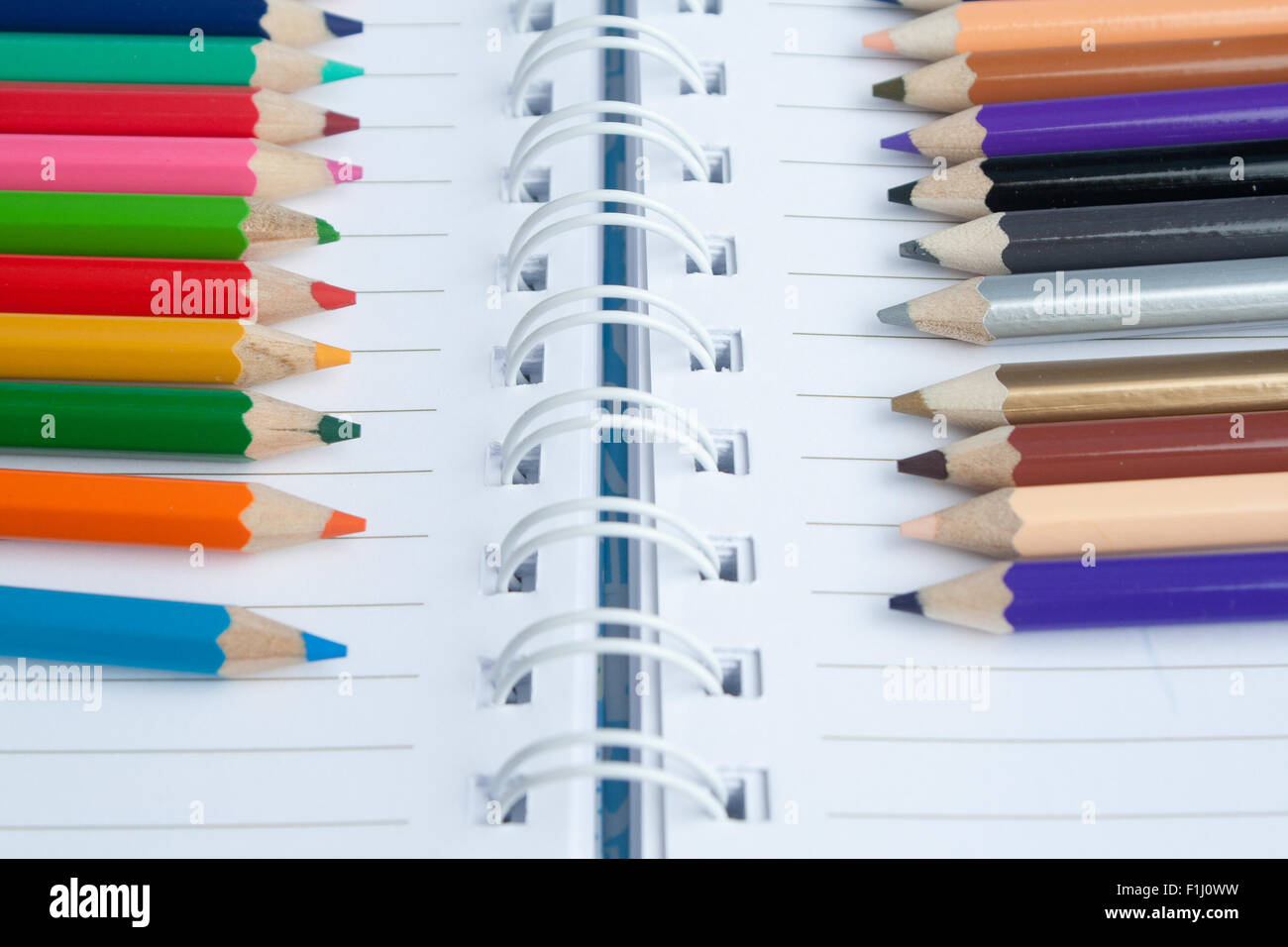 Note book and colored pencils Stock Photo - Alamy