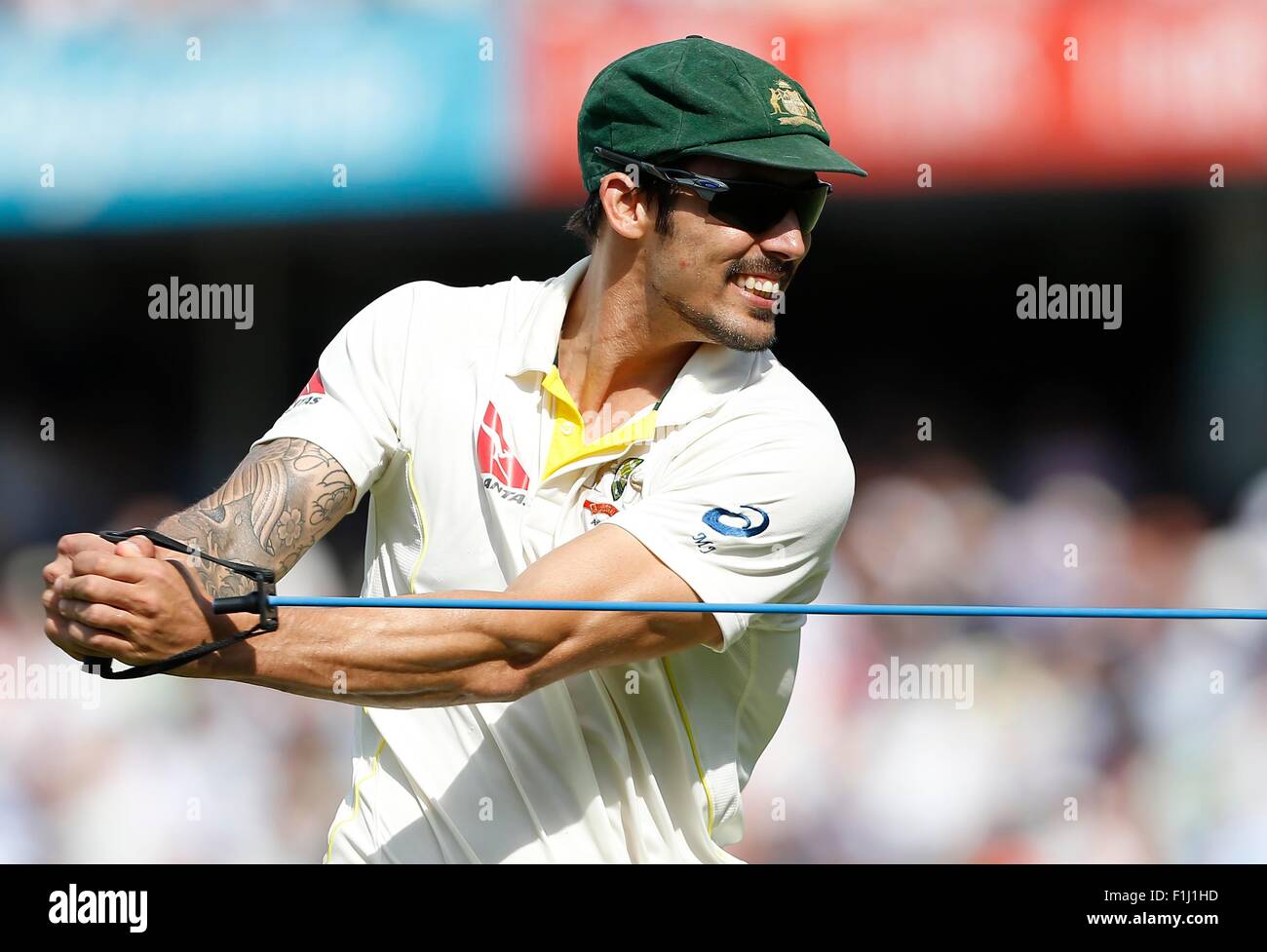 Australia’s Mitchell Johnson does some stretches before coming on to ...