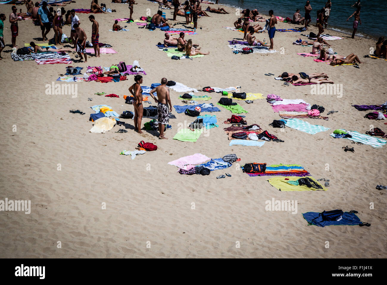 Tourists sunbathe at Barceloneta beach on a hot summer day Stock Photo ...