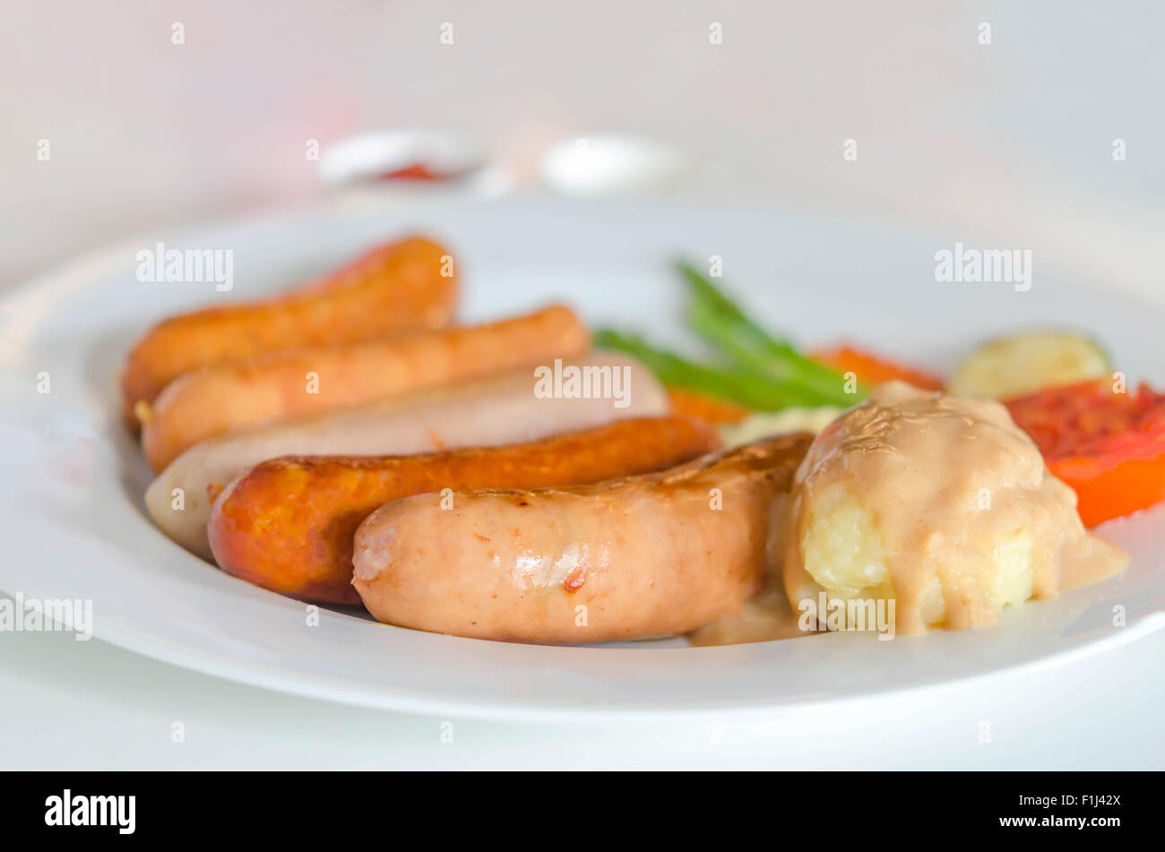 mixed grilled sausage served with mashed potato on dish Stock Photo - Alamy