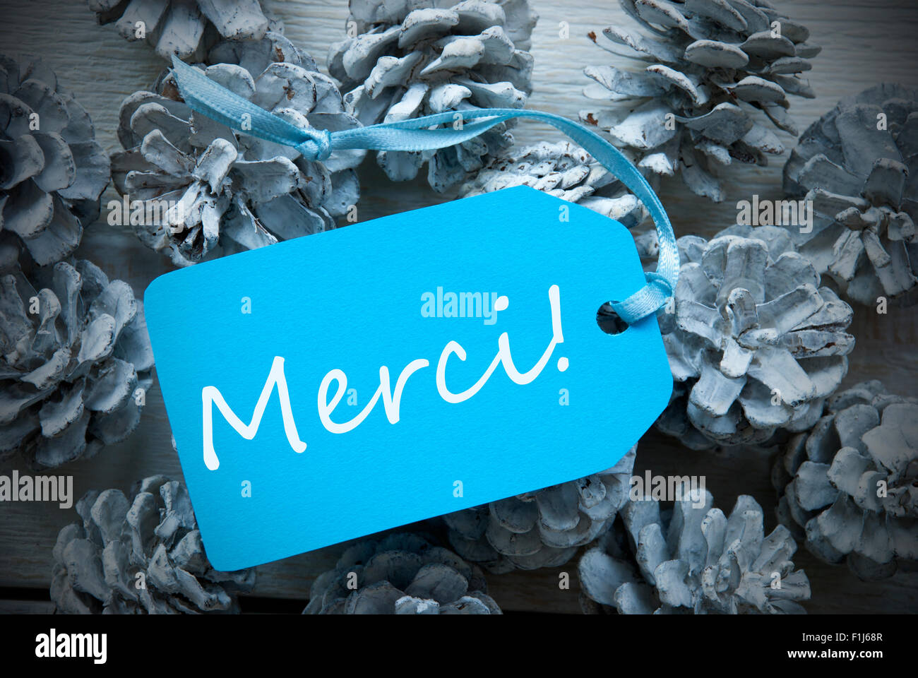 Light Blue Label On Fir Cones Merci Means Thank You Stock Photo - Alamy