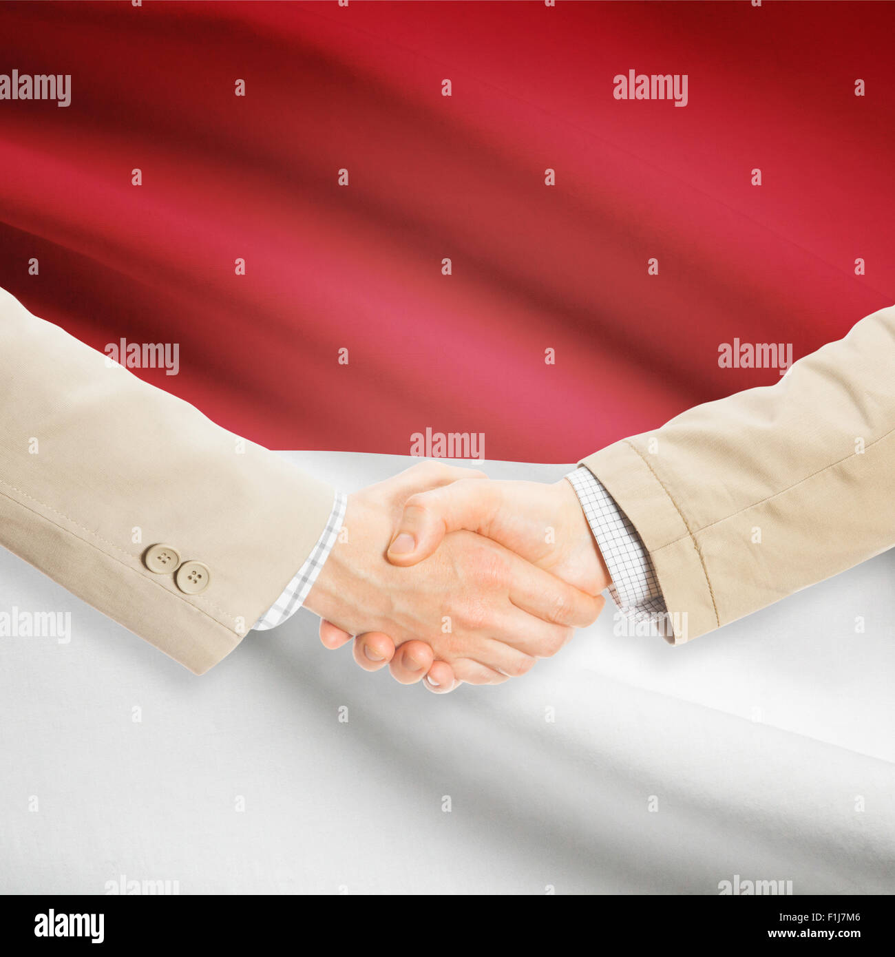 Businessmen shaking hands with flag on background - Indonesia Stock ...