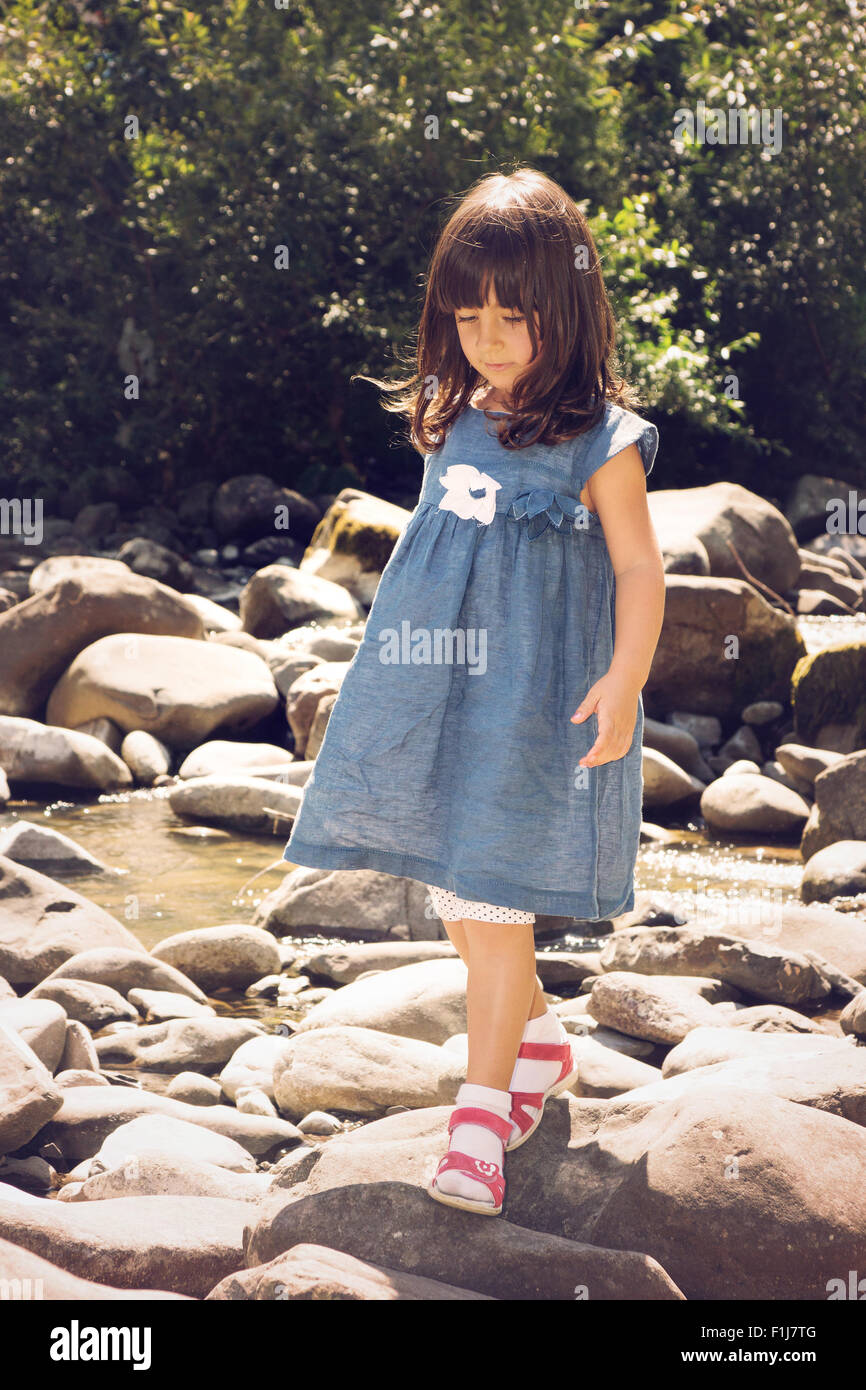 Little girl walk over the stones in the river Stock Photo - Alamy