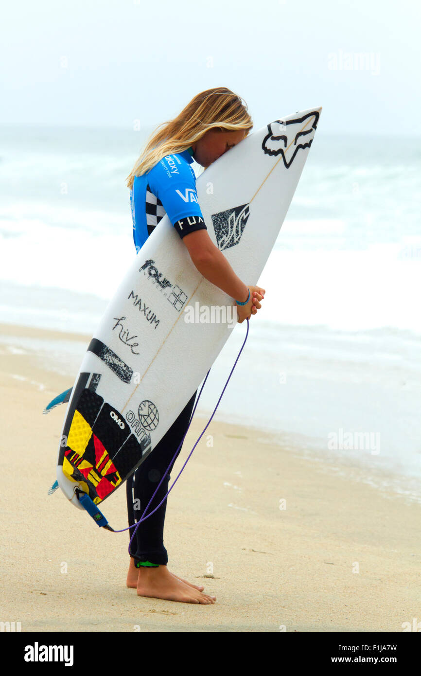 Professional female surfer getting focused before entering the ocean ...