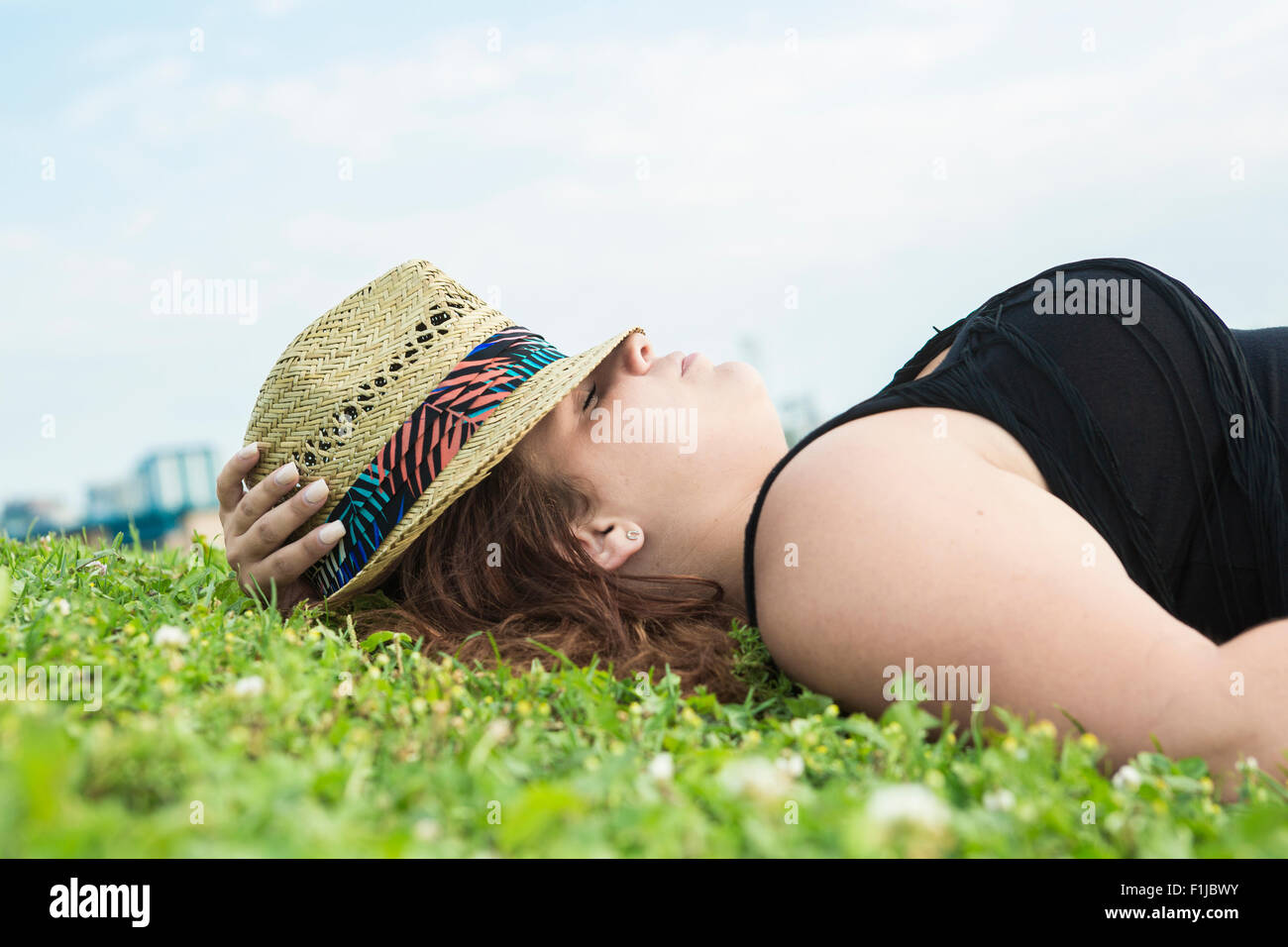Profile view of woman relaxing on grass Stock Photo - Alamy