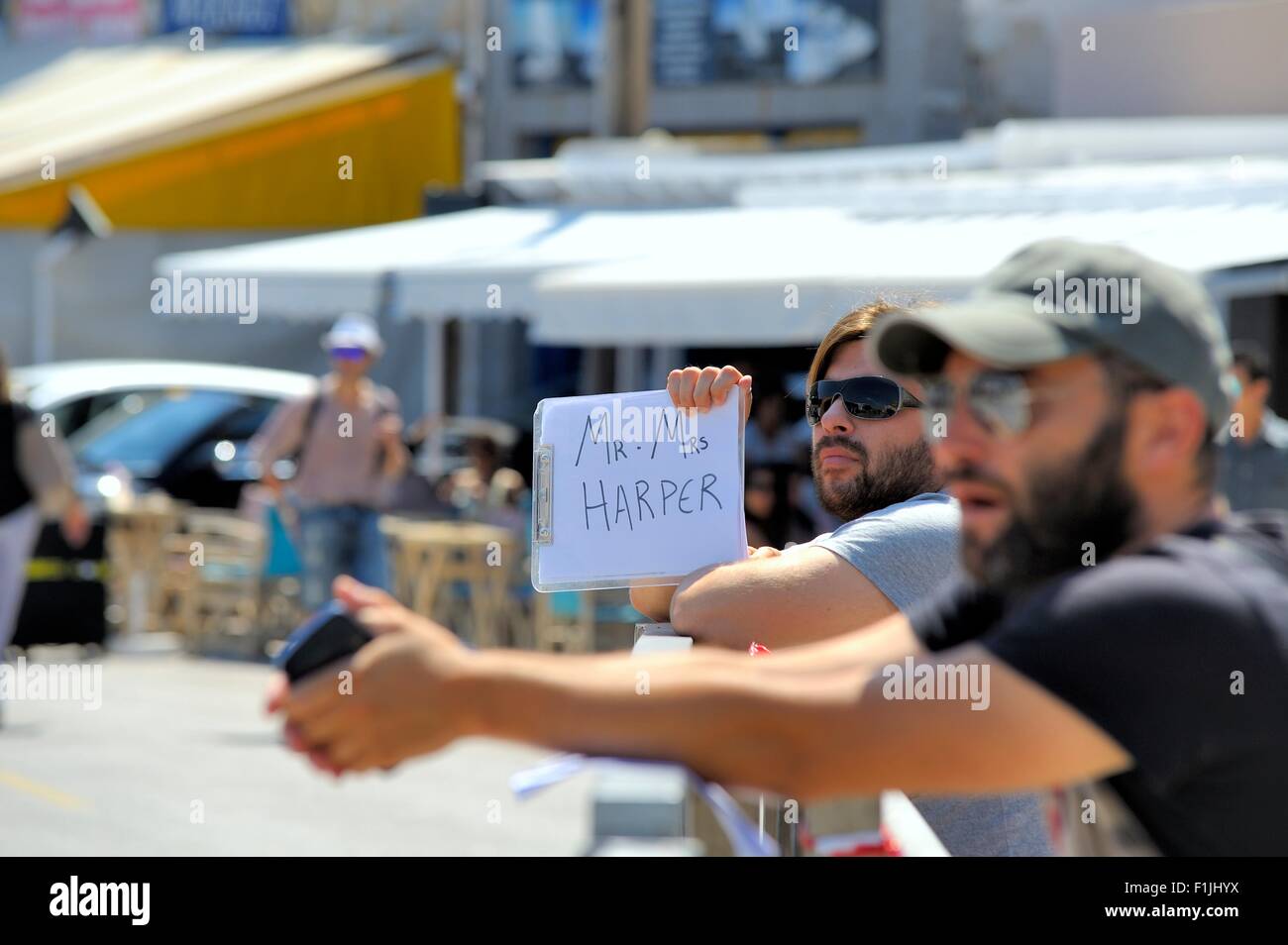 A Greek taxi driver holding a sign with the name of arriving ferry ...