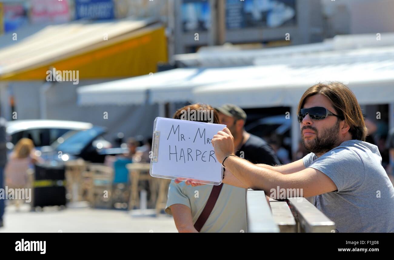 A Greek taxi driver holding a sign with the name of arriving ferry ...