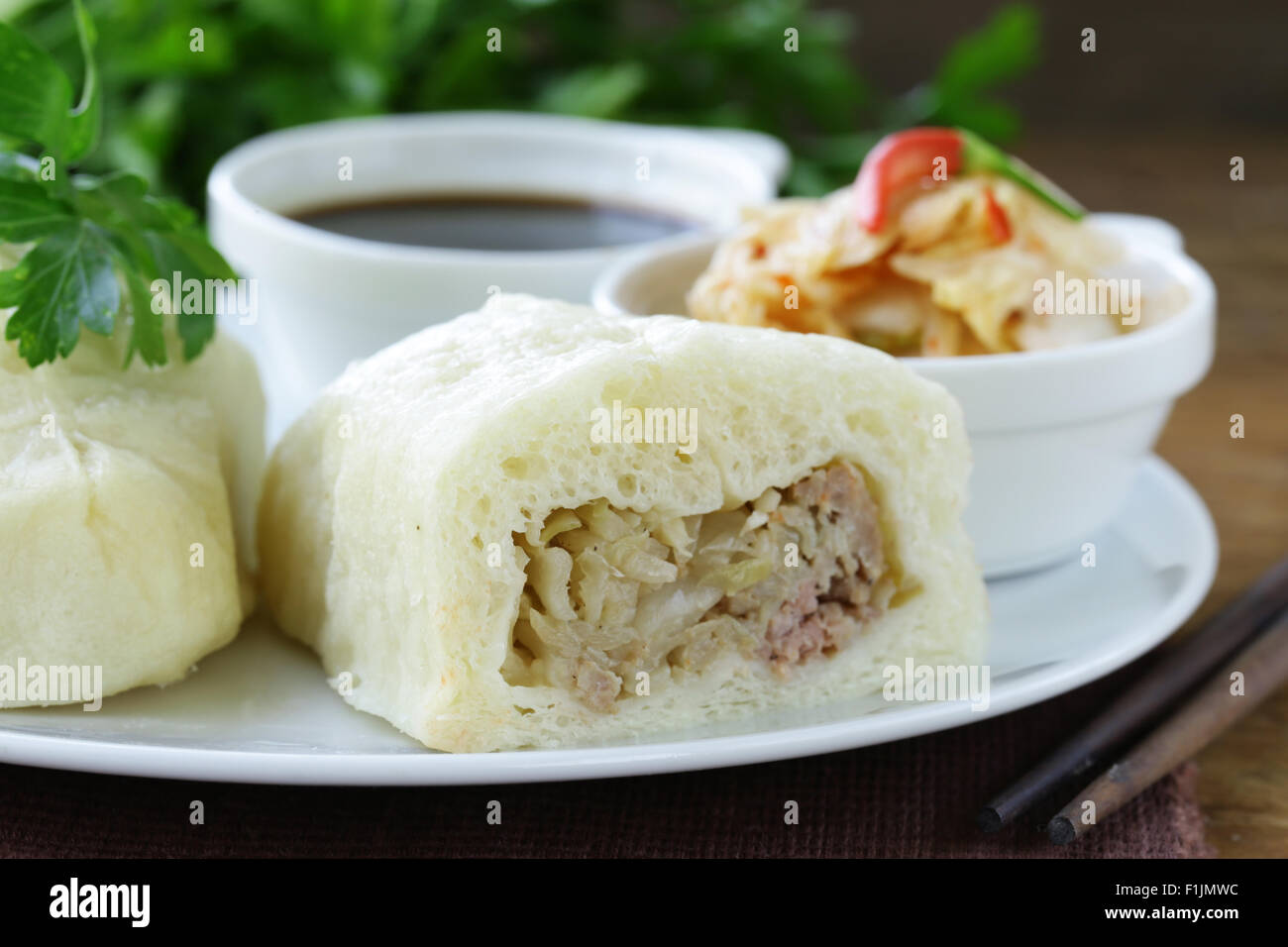 Korean steam meat pies (pigodi) served with soy sauce and kimchi Stock ...