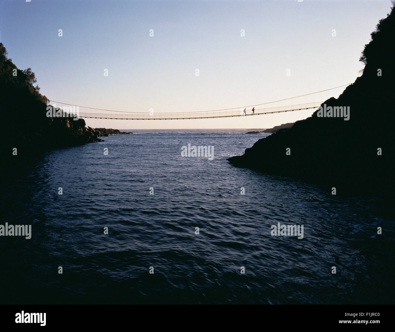 Silhouette of People Crossing Storms River Gorge on Rope Bridge, South ...