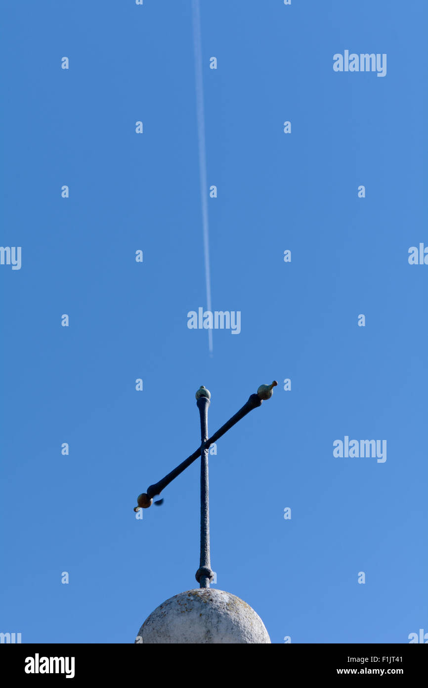 Grave cross in cemetery in Bordeaux, France with airplane jet stream in ...