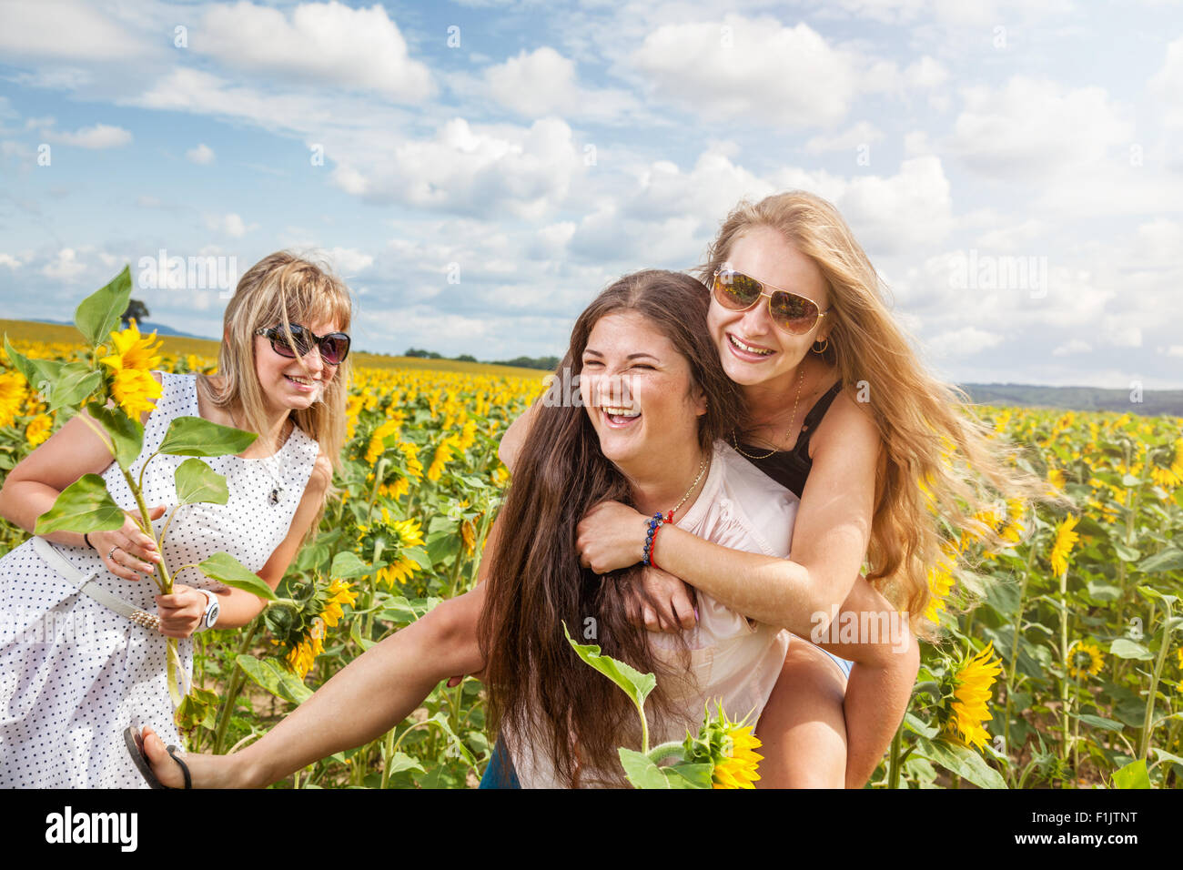 Three friends having a good time outdoors in a field Stock Photo - Alamy