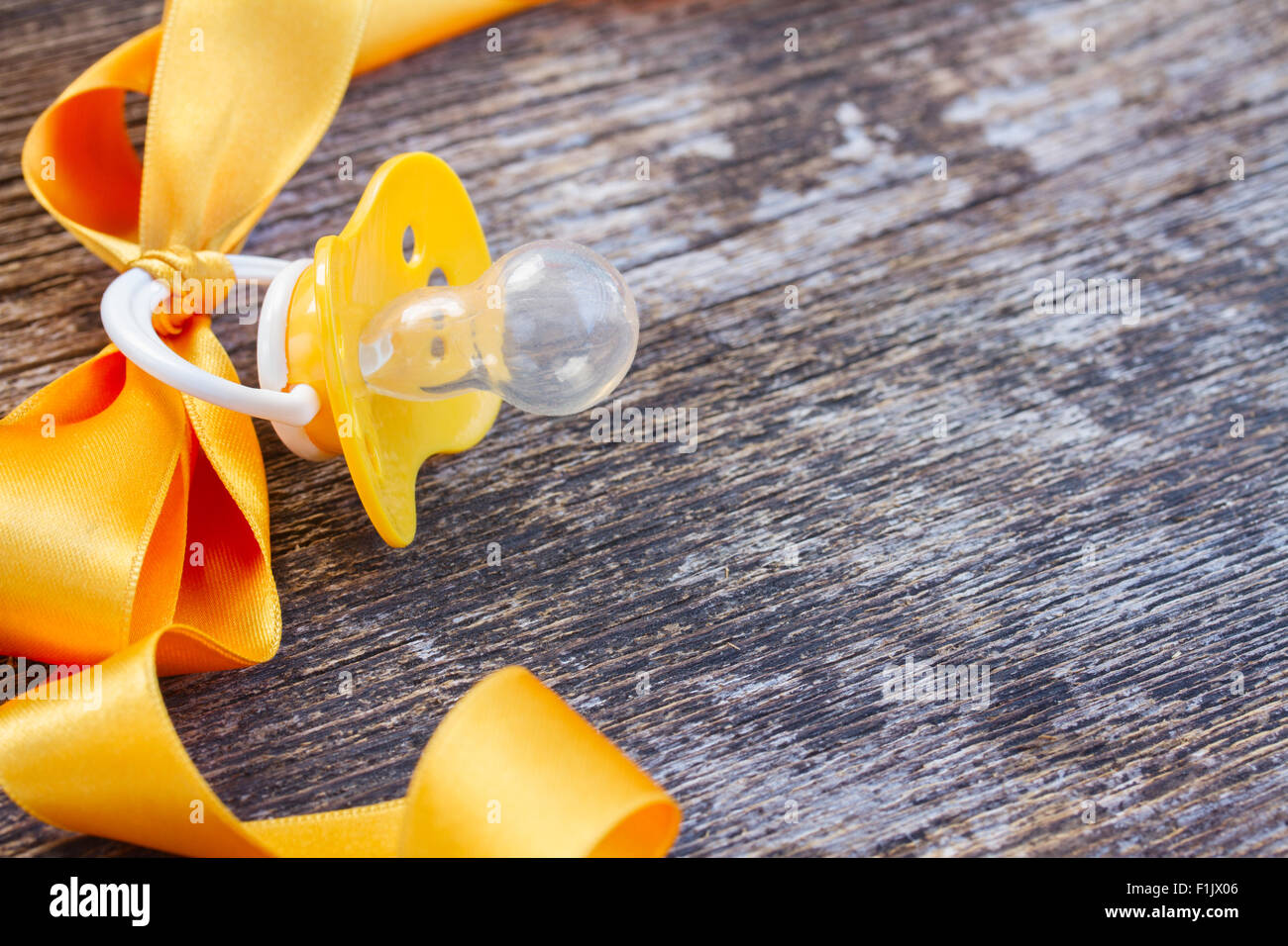 baby pacifier on wooden table Stock Photo - Alamy
