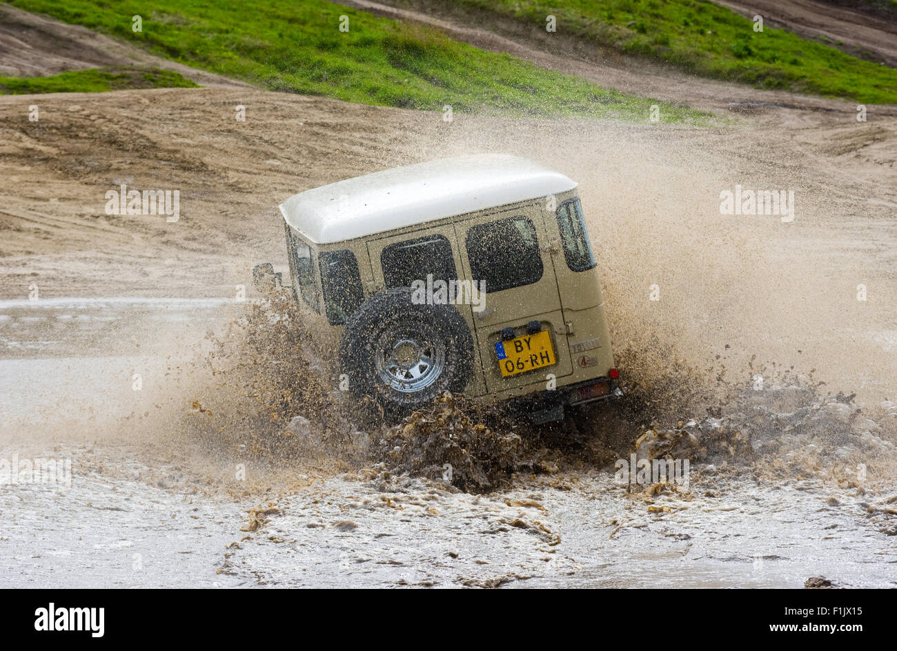 A Toyota 4-wheel drive is driving through a pond of water on a special ...