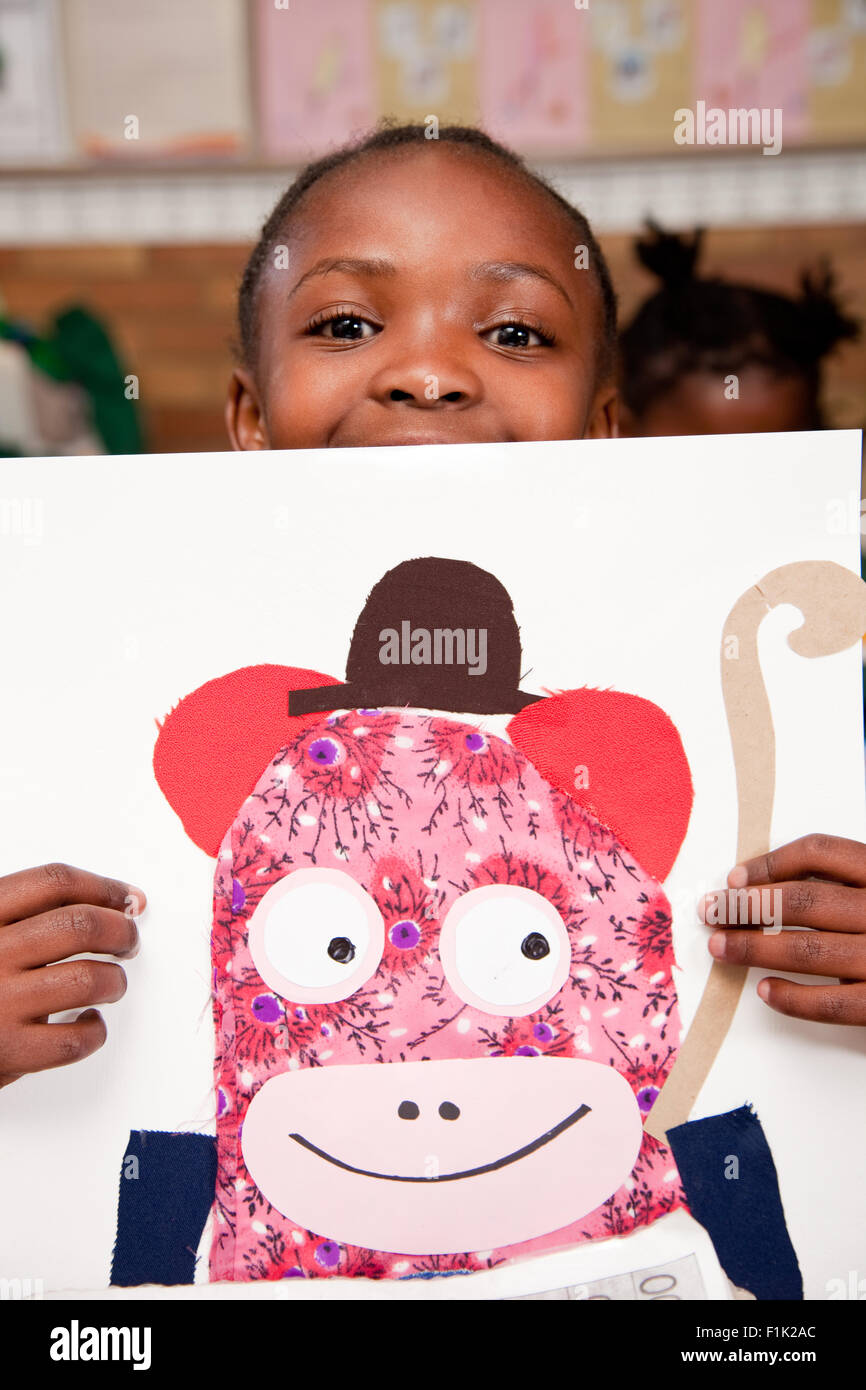 A young girl holding up her artwork, Meyerton Primary School, Meyerton ...