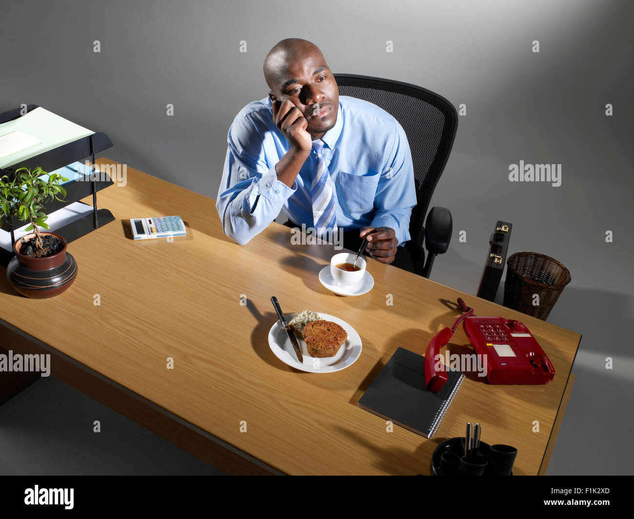 Bored businessman sitting at his desk Stock Photo - Alamy