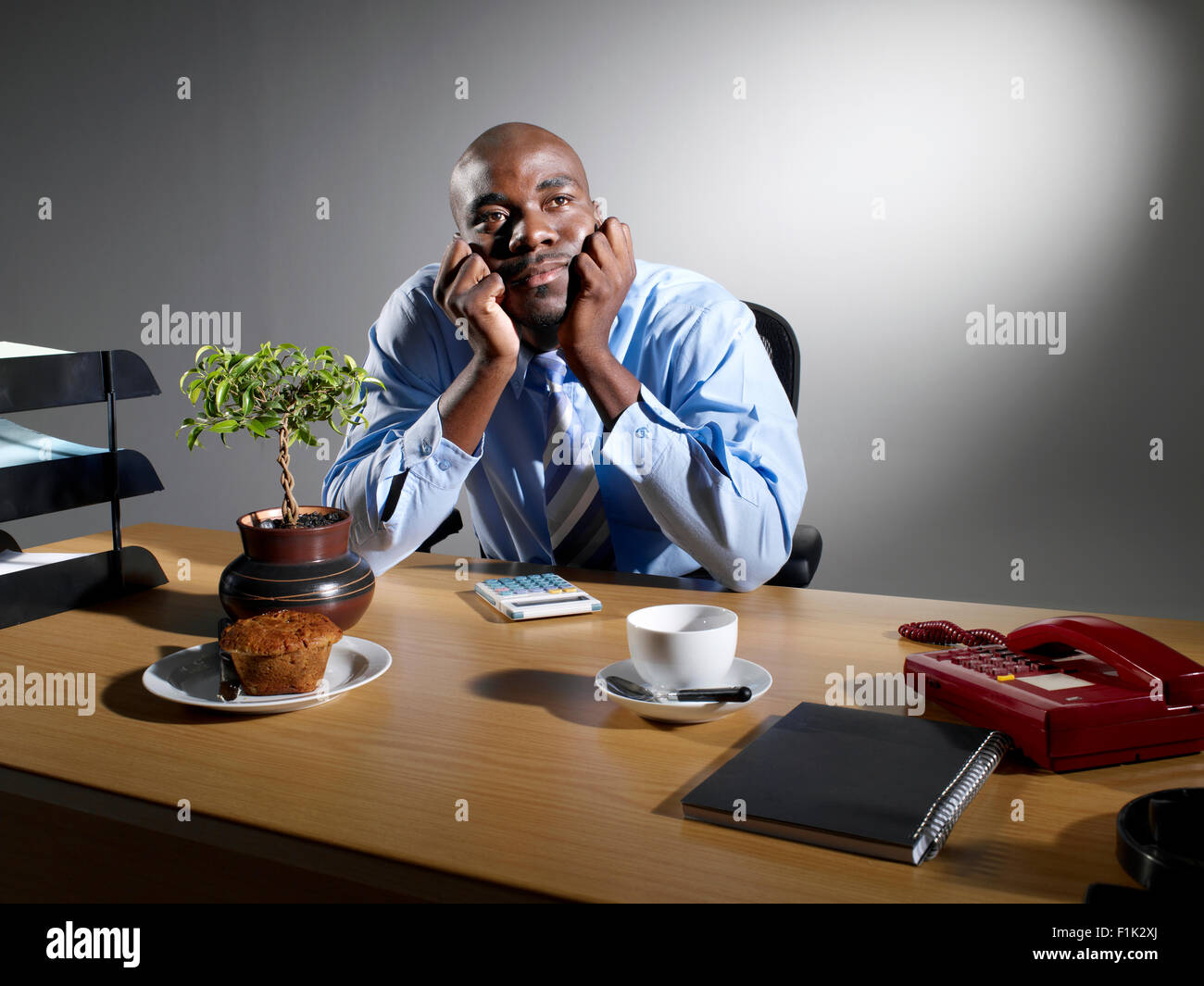 Bored businessman sitting at his desk Stock Photo - Alamy