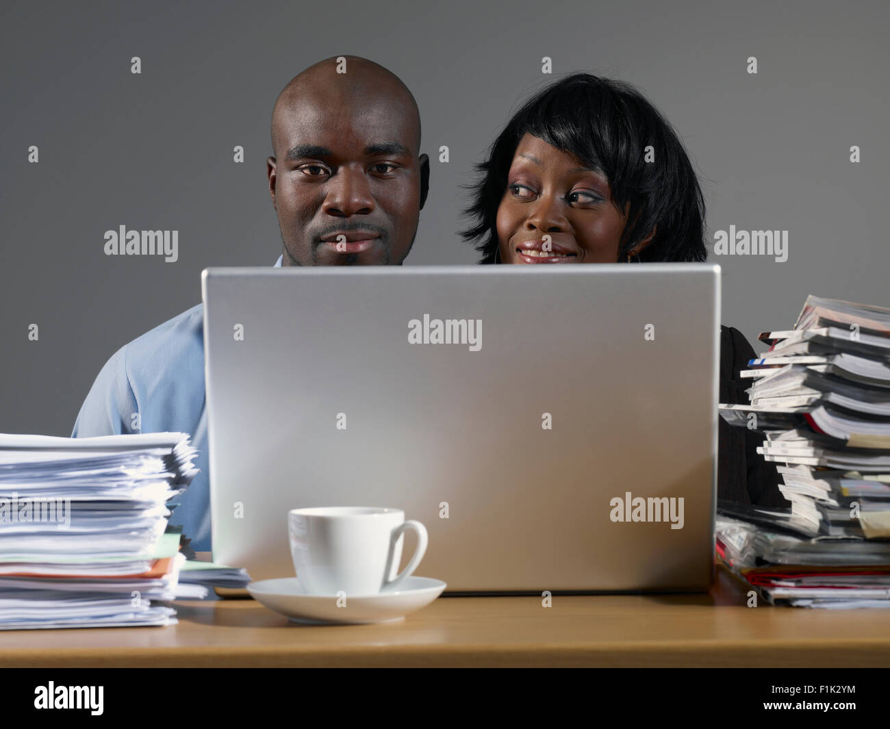 Co-workers working on laptop computer Stock Photo - Alamy