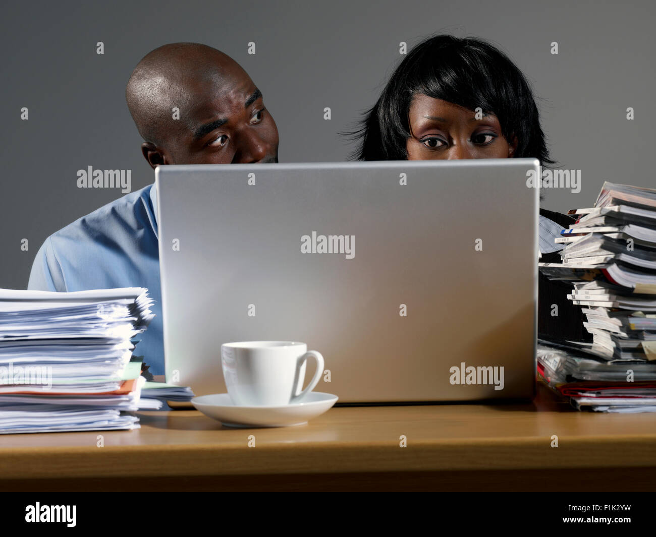Co-workers working on laptop computer Stock Photo - Alamy