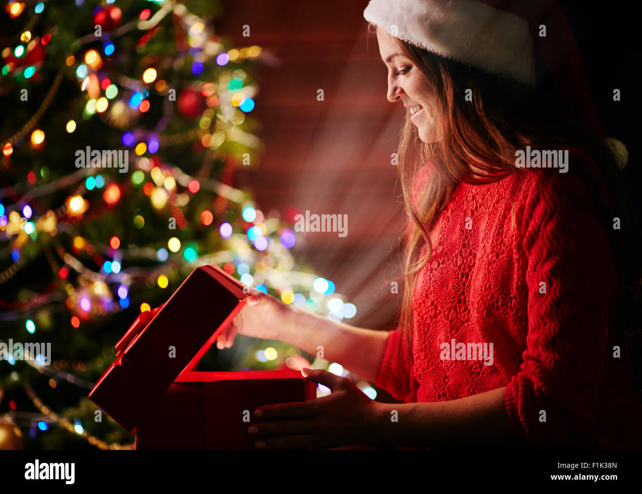 Female Santa opening magic box with gift on sparkling background Stock ...
