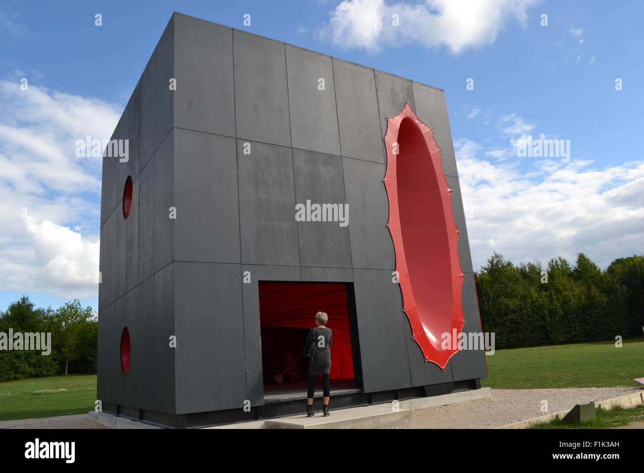 A woman stands by art work by Anish Kapoor in Versailles. The work is ...