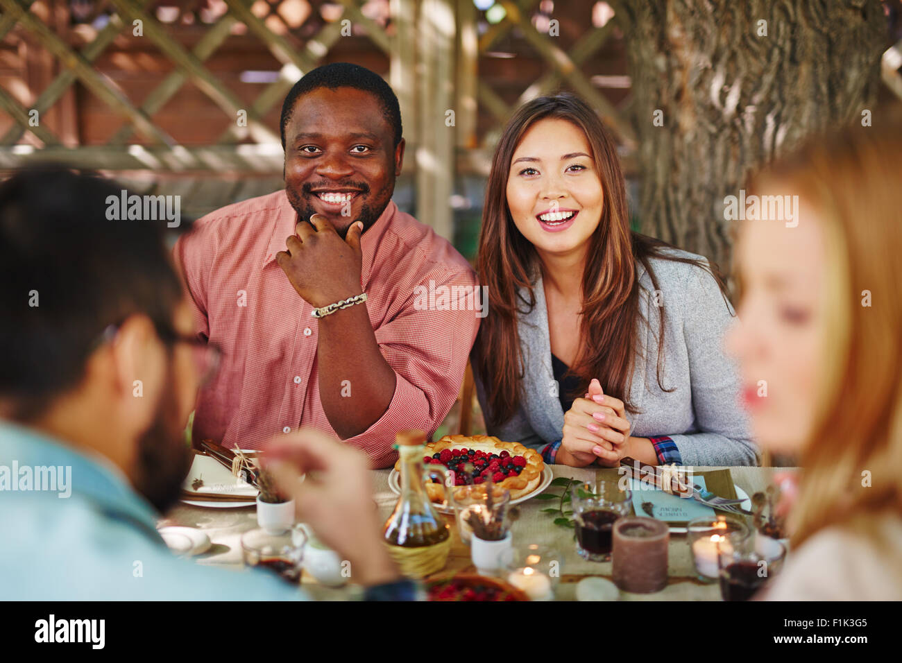 Happy young couple looking at camera by Thanksgiving table Stock Photo ...
