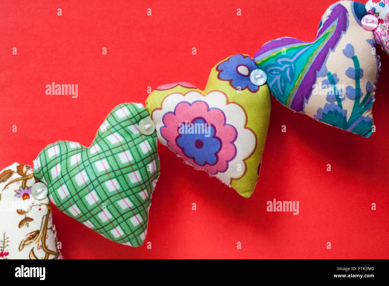 String of hearts made from fabric material attached with buttons set on ...