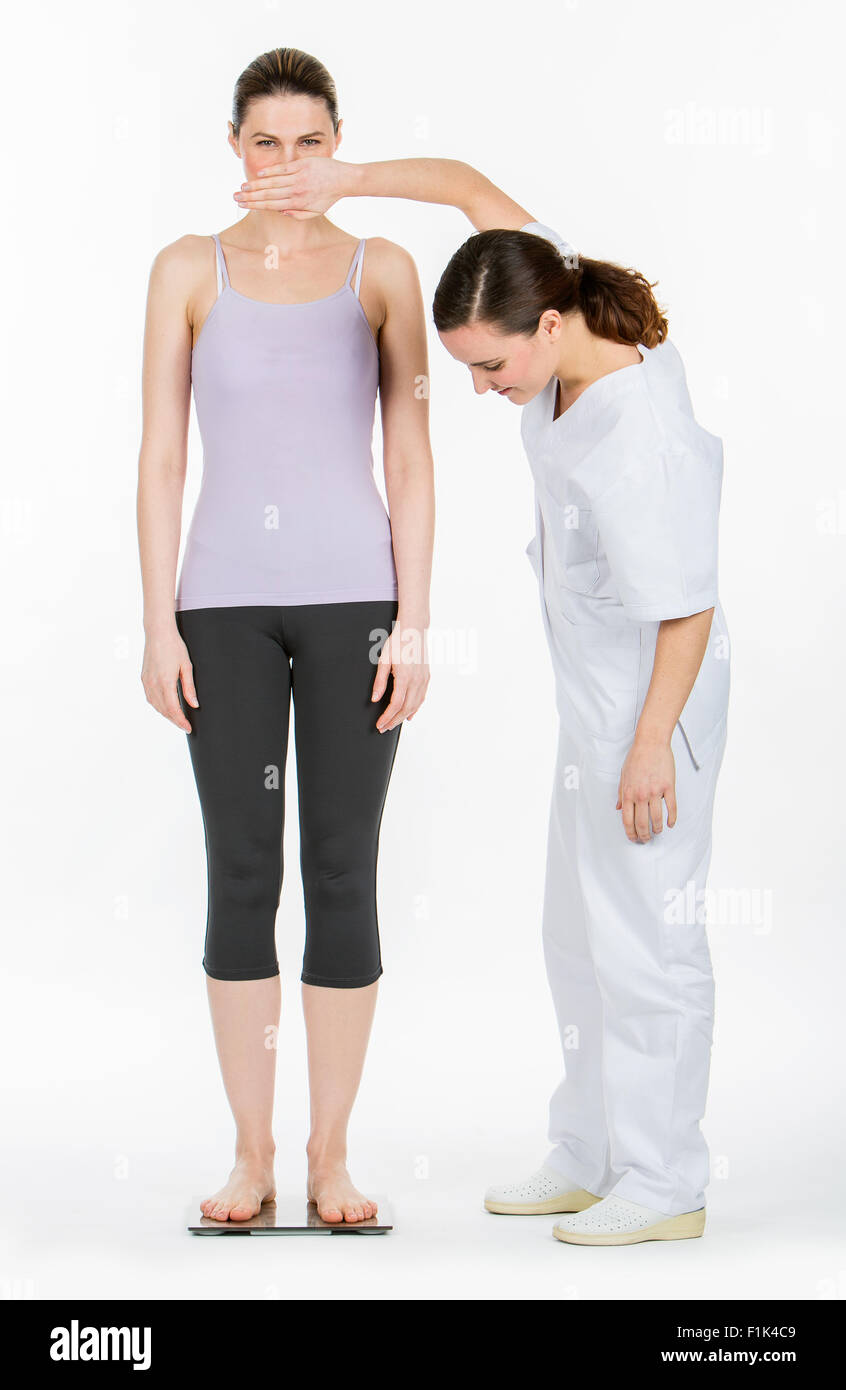 doctor with woman on weighing scale Stock Photo - Alamy